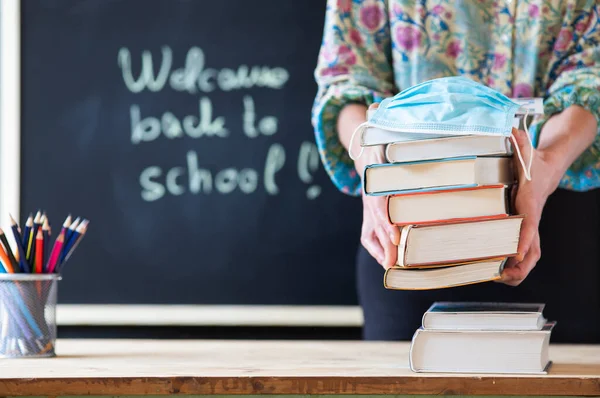 back to school concept during covid - pile of books and medical mask ...