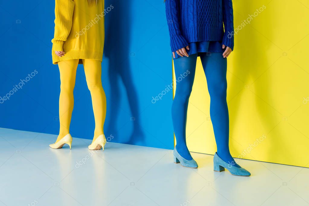 Vista recortada de las mujeres en ropa de contraste de pie espalda con ...