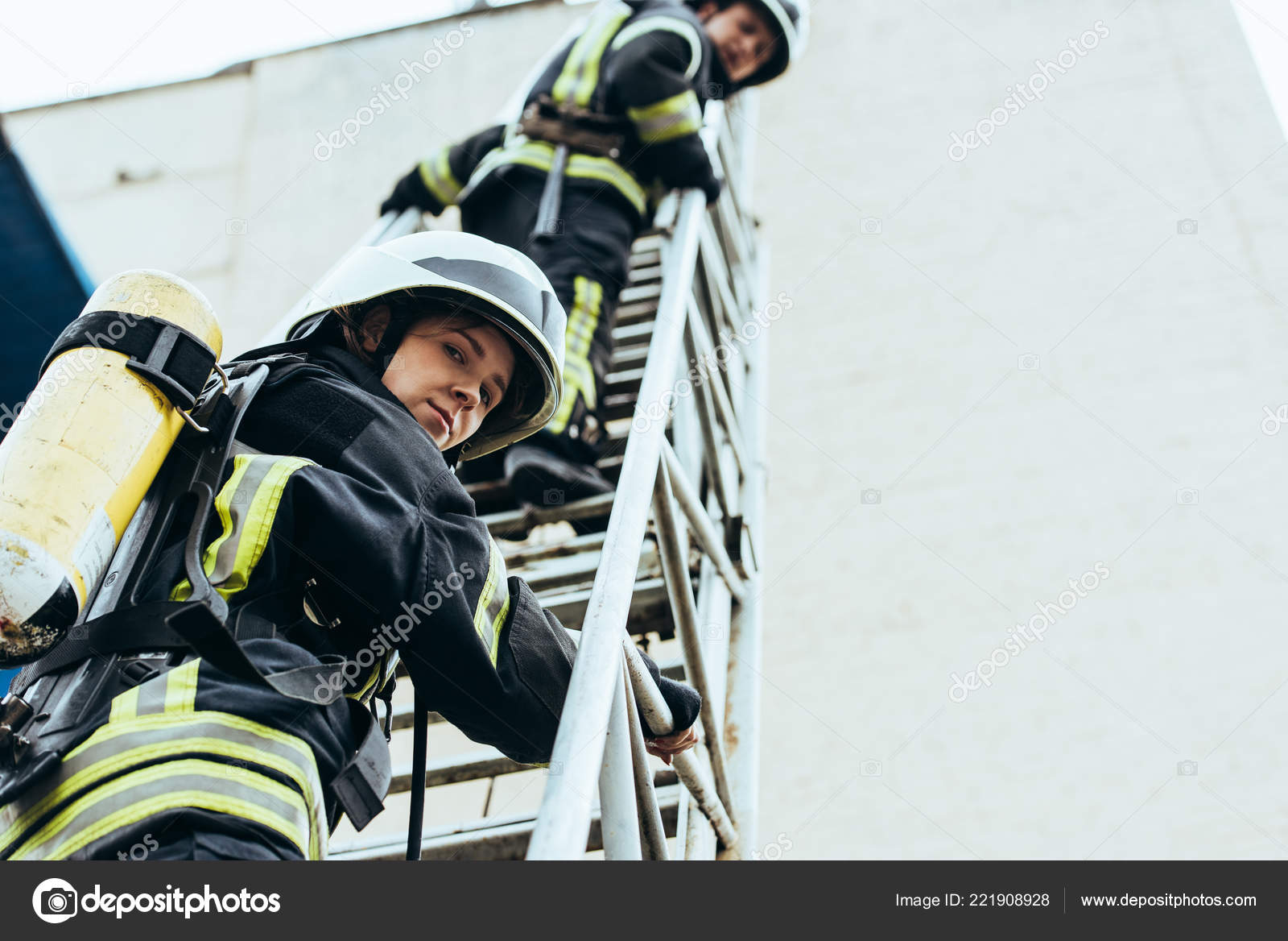 Low Angle View Firefighters Helmets Standing Ladder Looking Camera ...