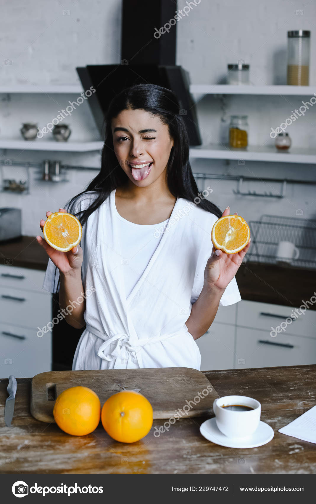 Beautiful Mixed Race Girl White Robe Holding Cut Orange Winking Stock