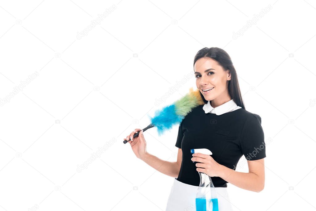 Morena mucama en uniforme sosteniendo plumero y spray botella aislado ...