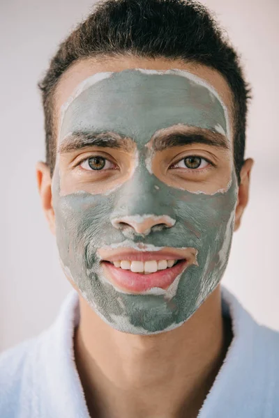portrait shot of handsome man with grey face mask smiling and looking ...
