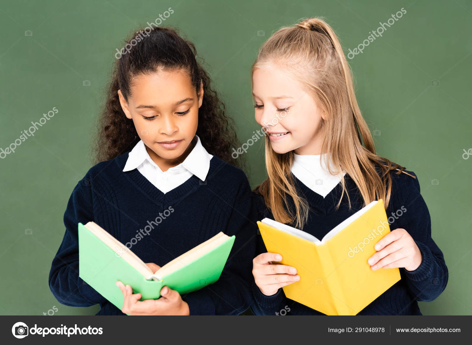 Two Cheerful Multicultural Schoolgirls Standing Reading Books Together ...