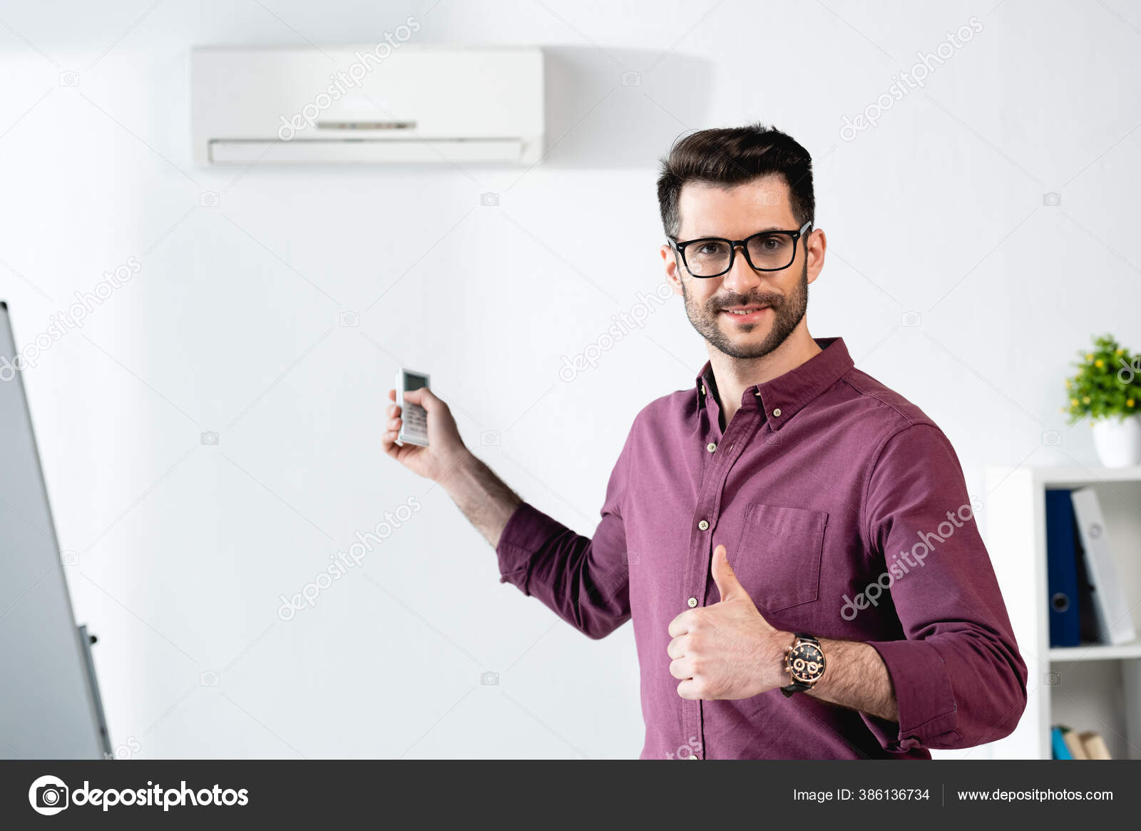 Smiling Businessman Showing Thumb While Switching Air Conditioner ... Smiling Businessman Showing Thumb While Switching Air Conditioner ...