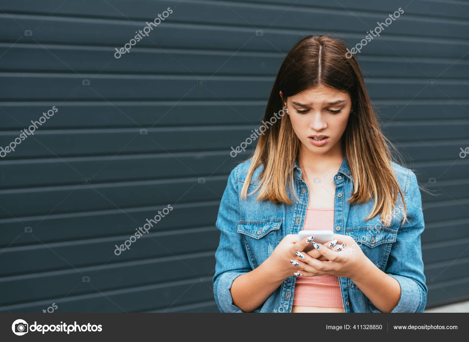Upset Teenager Using Smartphone Building Outdoor — Stock Photo © IgorVetushko #411328850