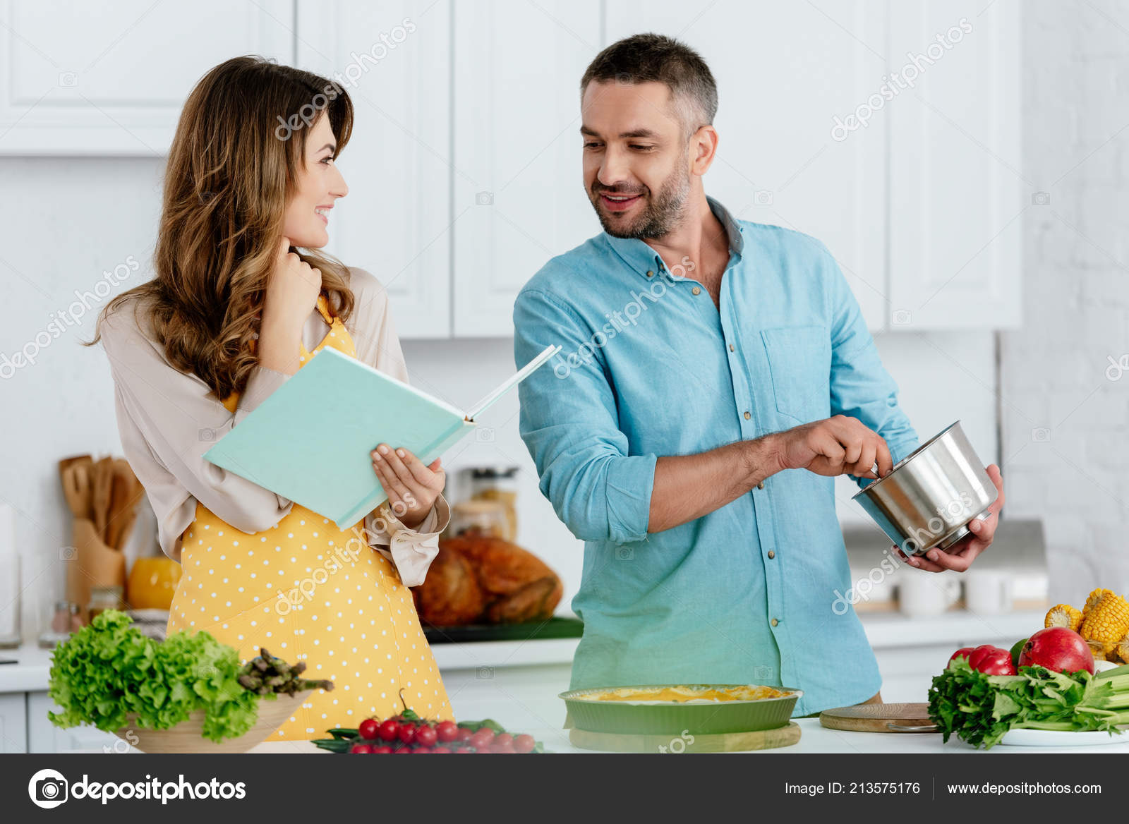 Smiling Couple Reading Recipe Book While Cooking Together Kitchen Stock ...