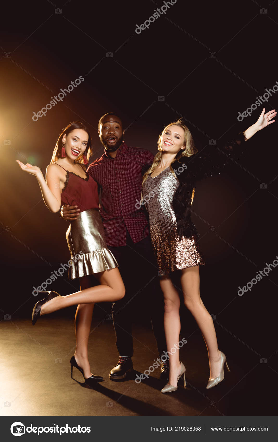 Smiling African American Man Hugging Two Attractive Women While
