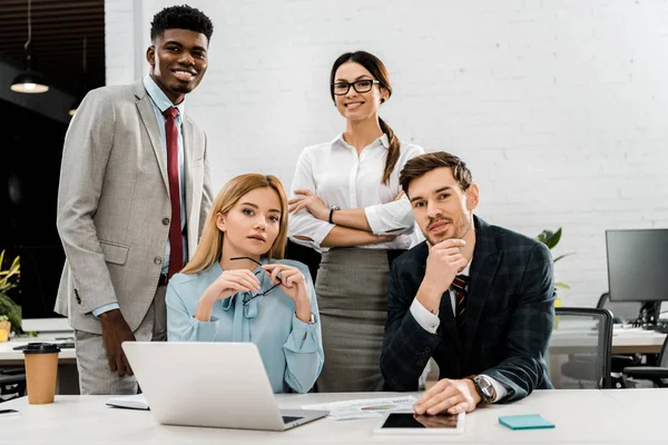 portrait of multiethnic business colleagues in formal wear at workplace ...