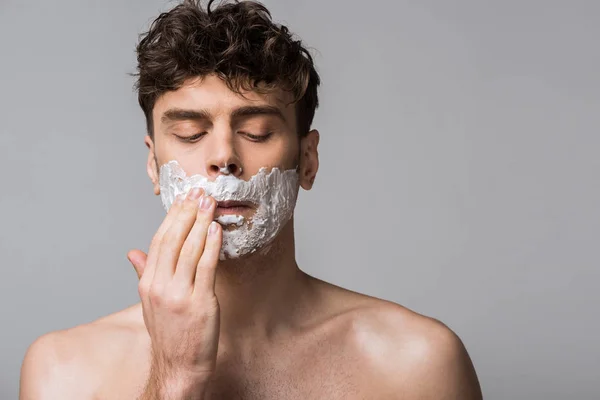 handsome man applying shaving foam on face, isolated on grey - Stock Image - Everypixel