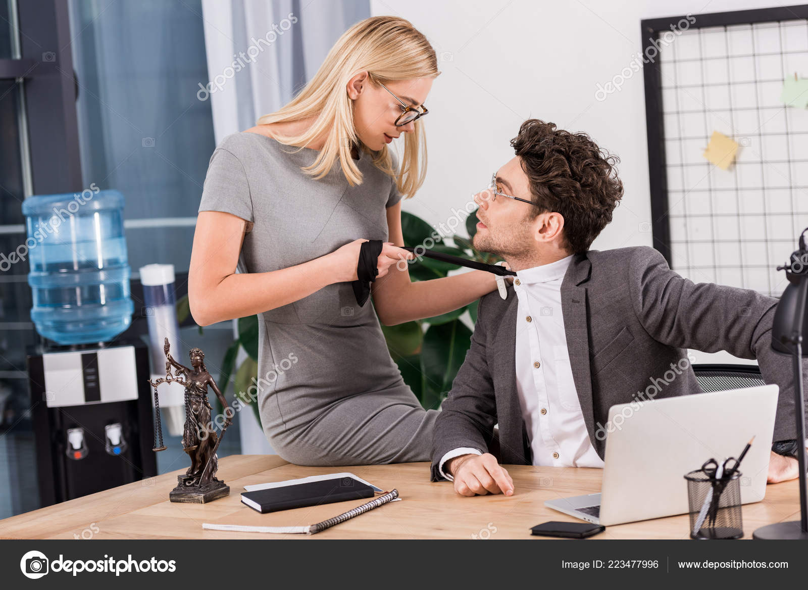 Young Businesswoman Pulling Colleagues Tie While Sitting Table Office ...