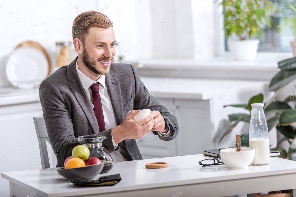 hombre de negocios guapo desayunando y tomando café en la mesa de la ...
