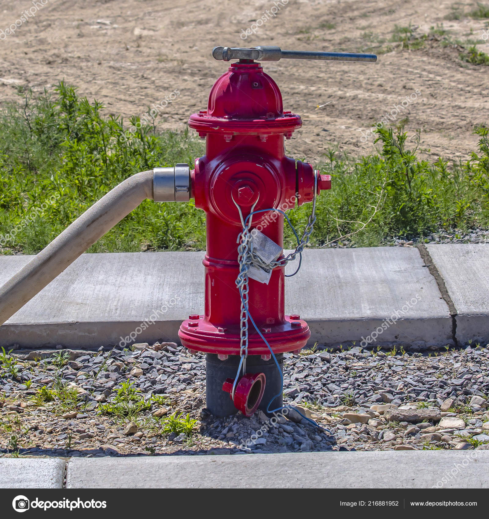 Fire hydrant with an affixed hose and wrench — Stock Photo ...