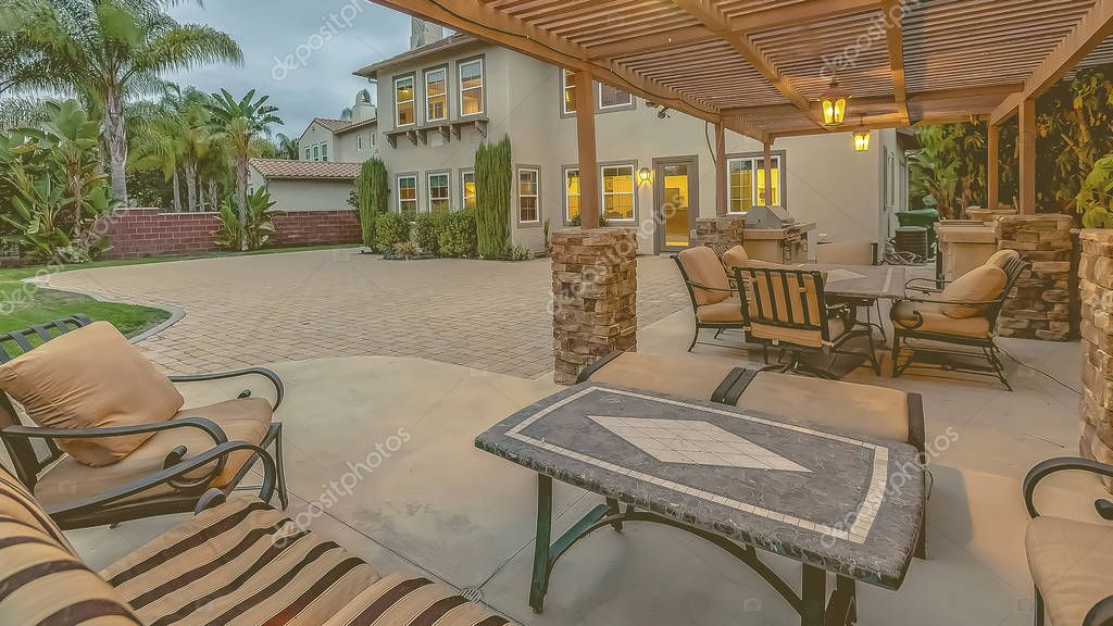 Marco panorámico Comedor exterior bajo una pérgola de madera en el ...