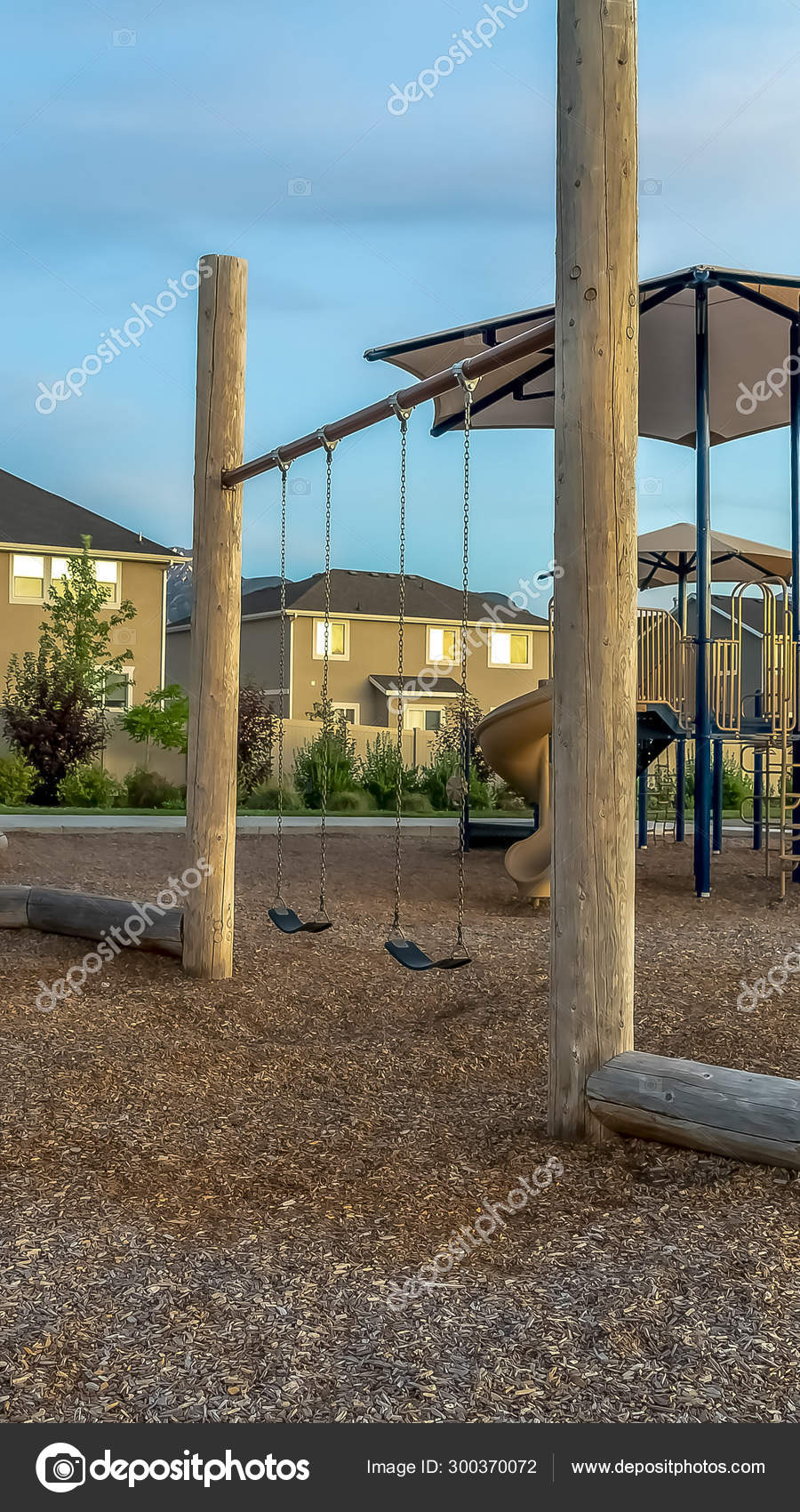Vertical Neighborhood playground with slides and swings against homes ...