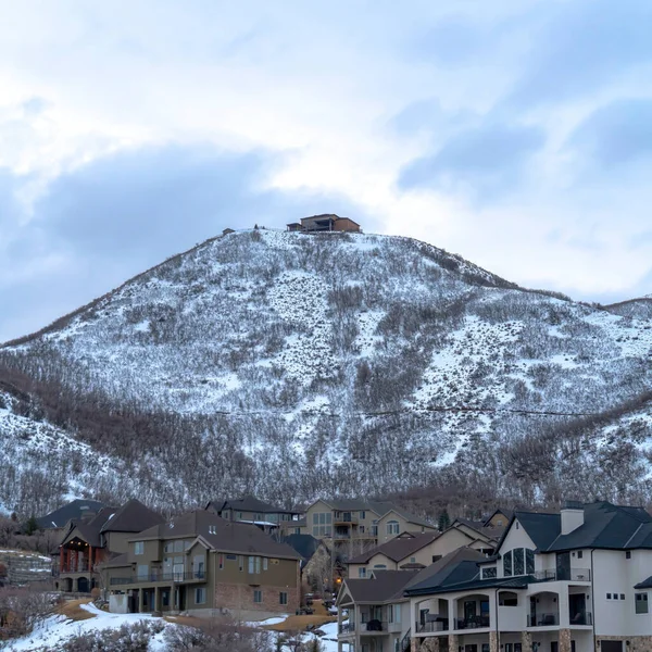 Square crop Homes built on the slopes of a hill overlooking cloud ...