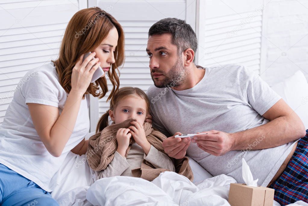 mamá llamando al médico y papá comprobar la temperatura de la hija ... mamá llamando al médico y papá comprobar la temperatura de la hija ...