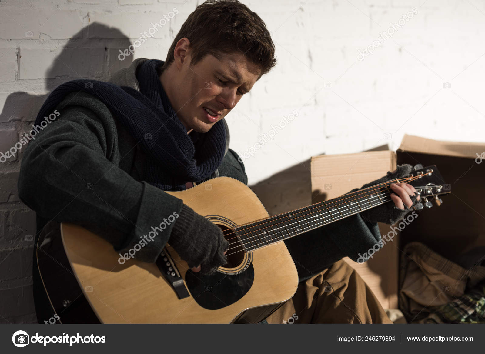 Sad Homeless Man Playing Guitar While Sitting White Brick Wall Stock ...