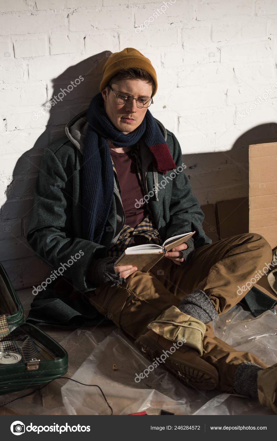 Homeless Man Reading Book While Sitting White Brick Wall Stock Photo by ...