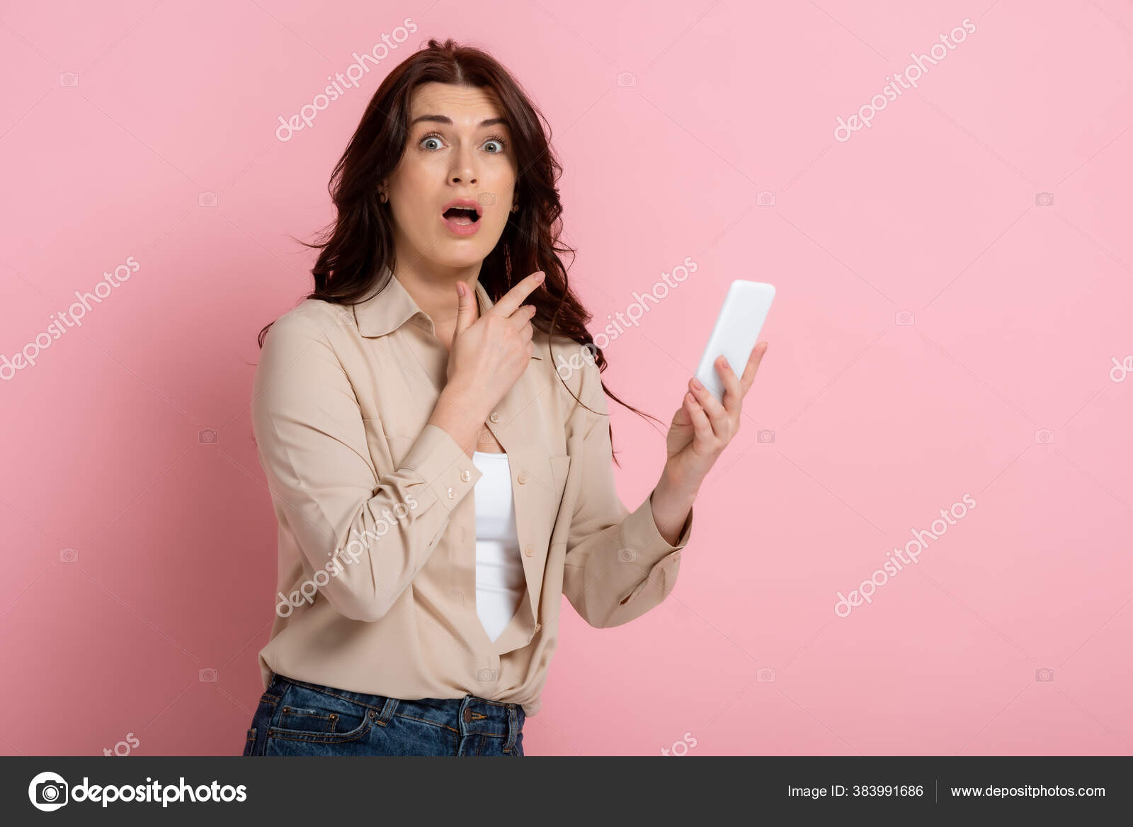 Scared Woman Looking Camera Pointing Finger While Holding Smartphone ...
