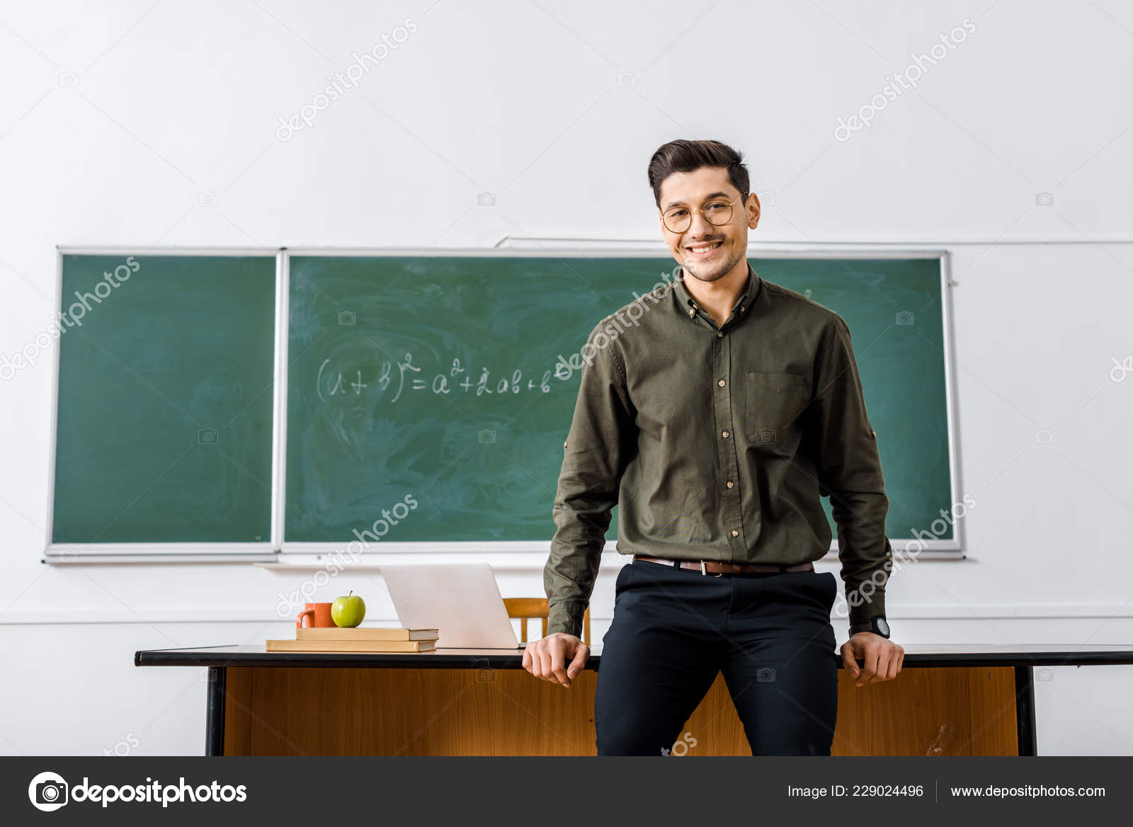 Smiling Male Teacher Formal Wear Looking Camera Standing Desk Classroom ... Smiling Male Teacher Formal Wear Looking Camera Standing Desk Classroom ...