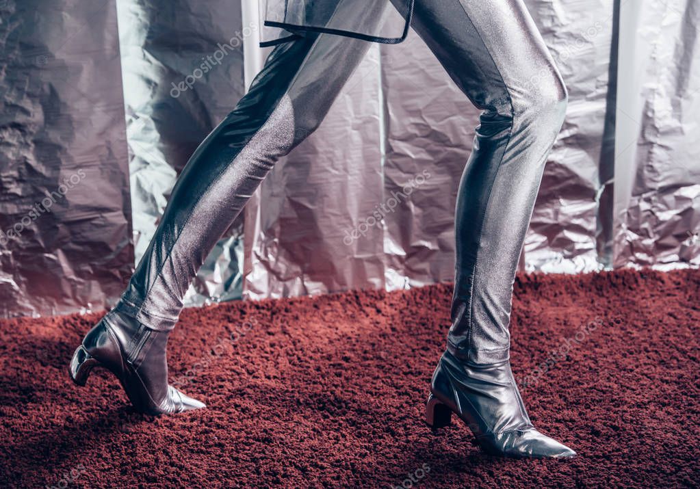 vista parcial del modelo posando en body plateado y calzado sobre fondo ...