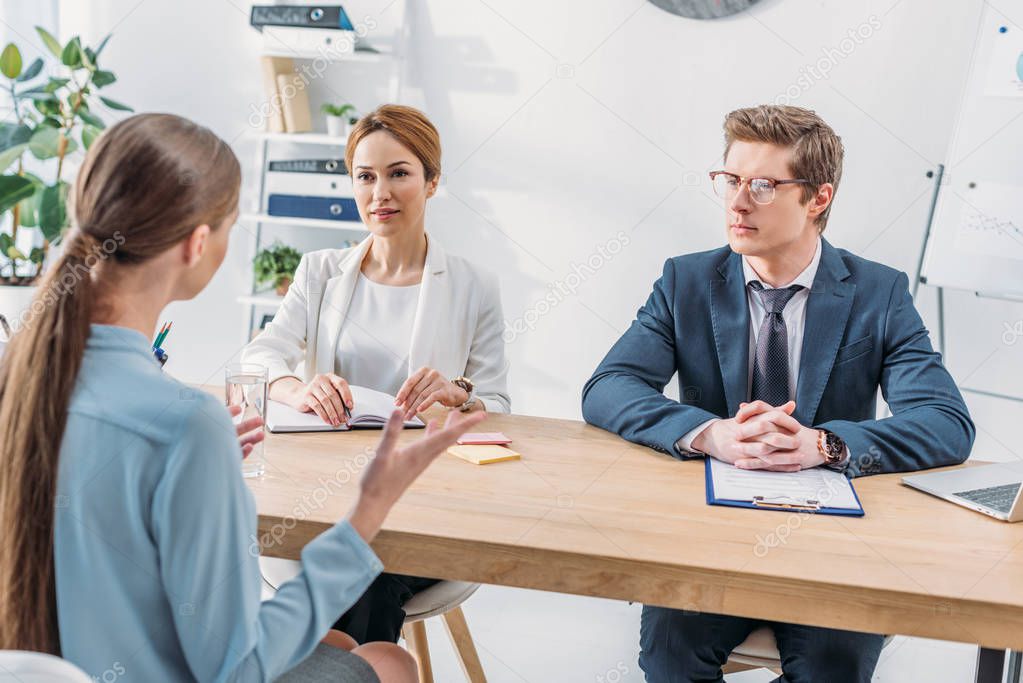 vista posterior de la mujer hablando con los reclutadores durante la ...