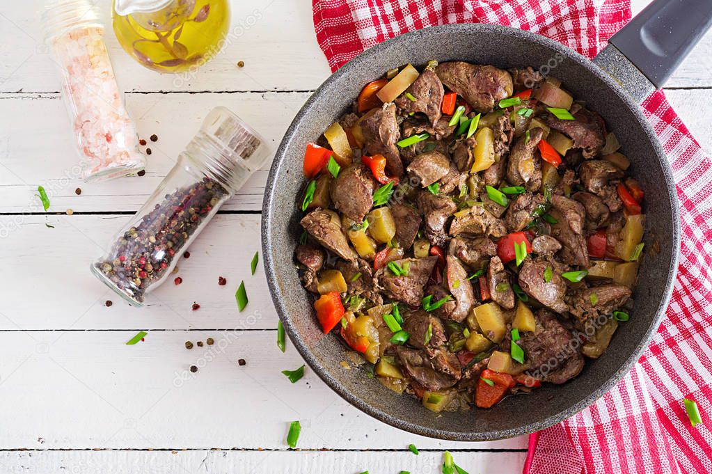 Hígado de pollo frito con manzanas y pimentón en sartén. Vista superior ...