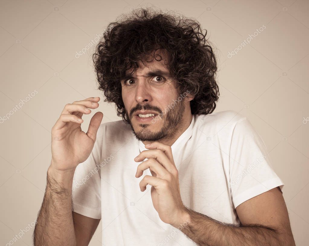 Retrato de un joven en estado de shock con la cara asustada haciendo gestos asustados y mirando ...