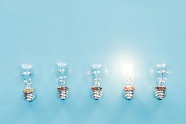 Top View Light Bulbs Row One Them Glowing Blue Background — Stock Photo ...