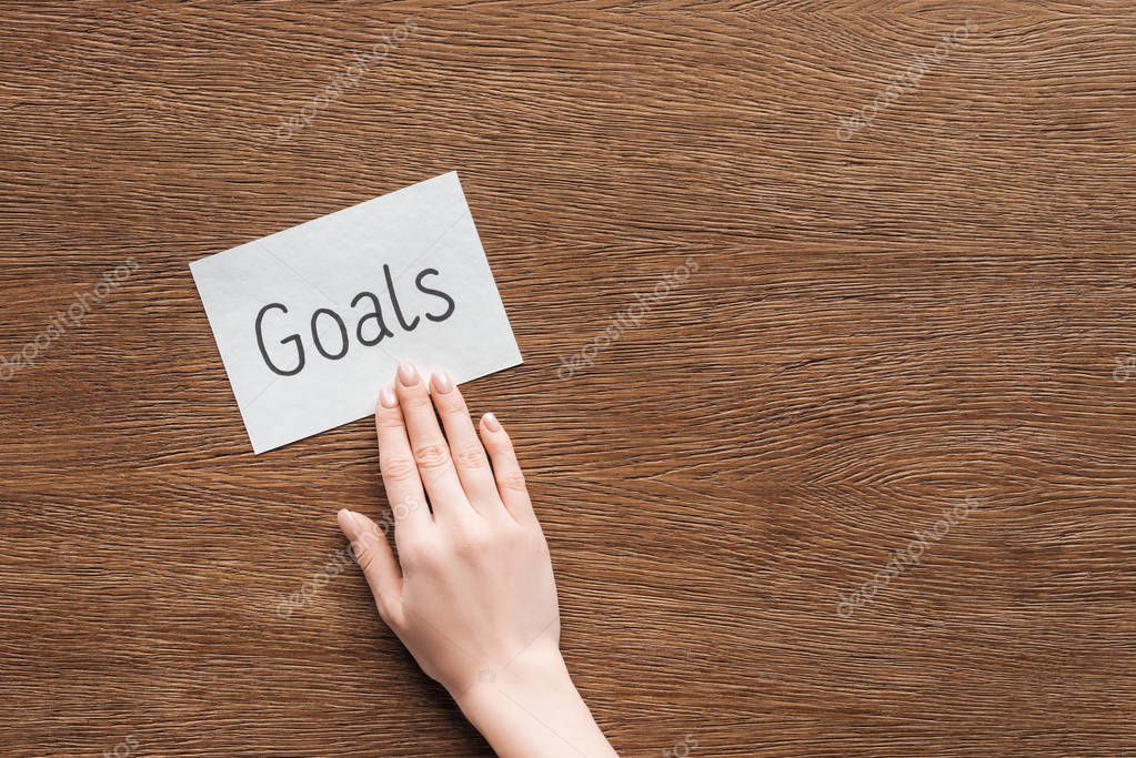 vista parcial de la mujer apuntando a las letras 'metas' en la tarjeta ...