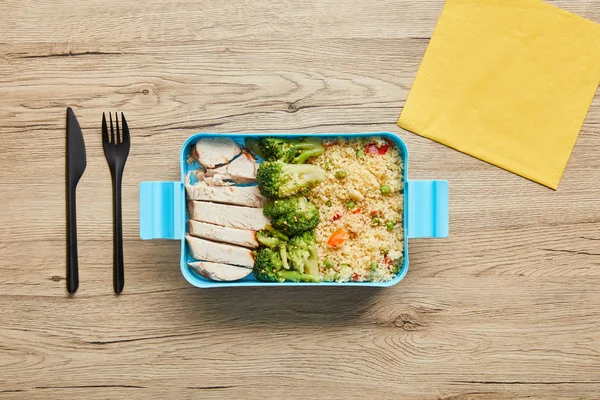 Top view of lunch box with risotto, broccoli and chicken on wooden ...
