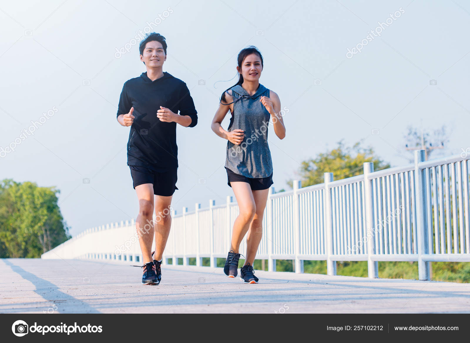 Young couple runner running on running road in city park Stock Photo by ...