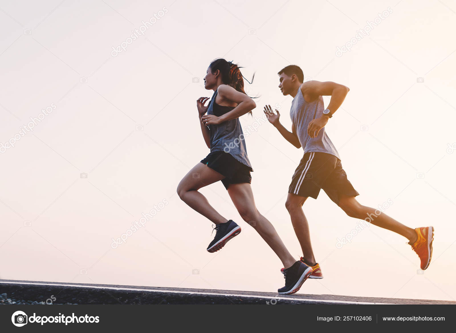Young couple runner running on running road in city park — Stock Photo ...