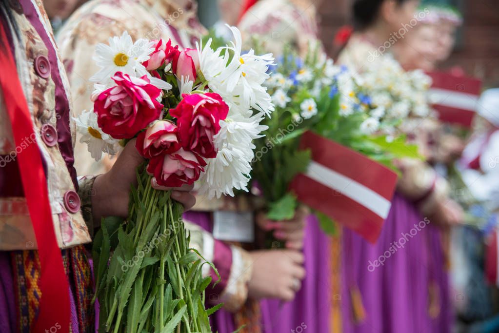 Elementos y trajes nacionales letones, personas con ramos de flores de ...