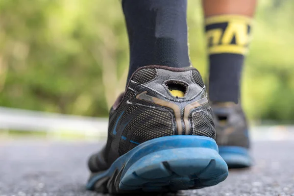 Start to run concept. Man runner feet on road in Park workout wellness ...