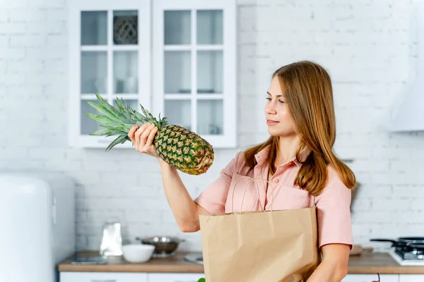 Woman with the grocery store packet in the hands. Kitchen background ...