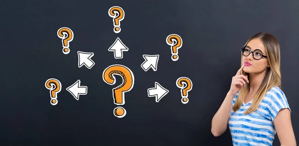 Puntos de interrogación grandes y pequeños con flechas con persona usando un portátil ...