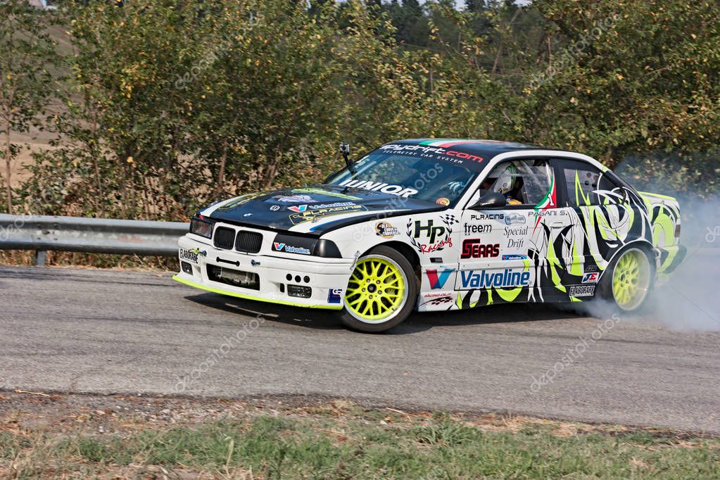 un coche de carreras de deriva BMW en acción con neumáticos humeantes ...