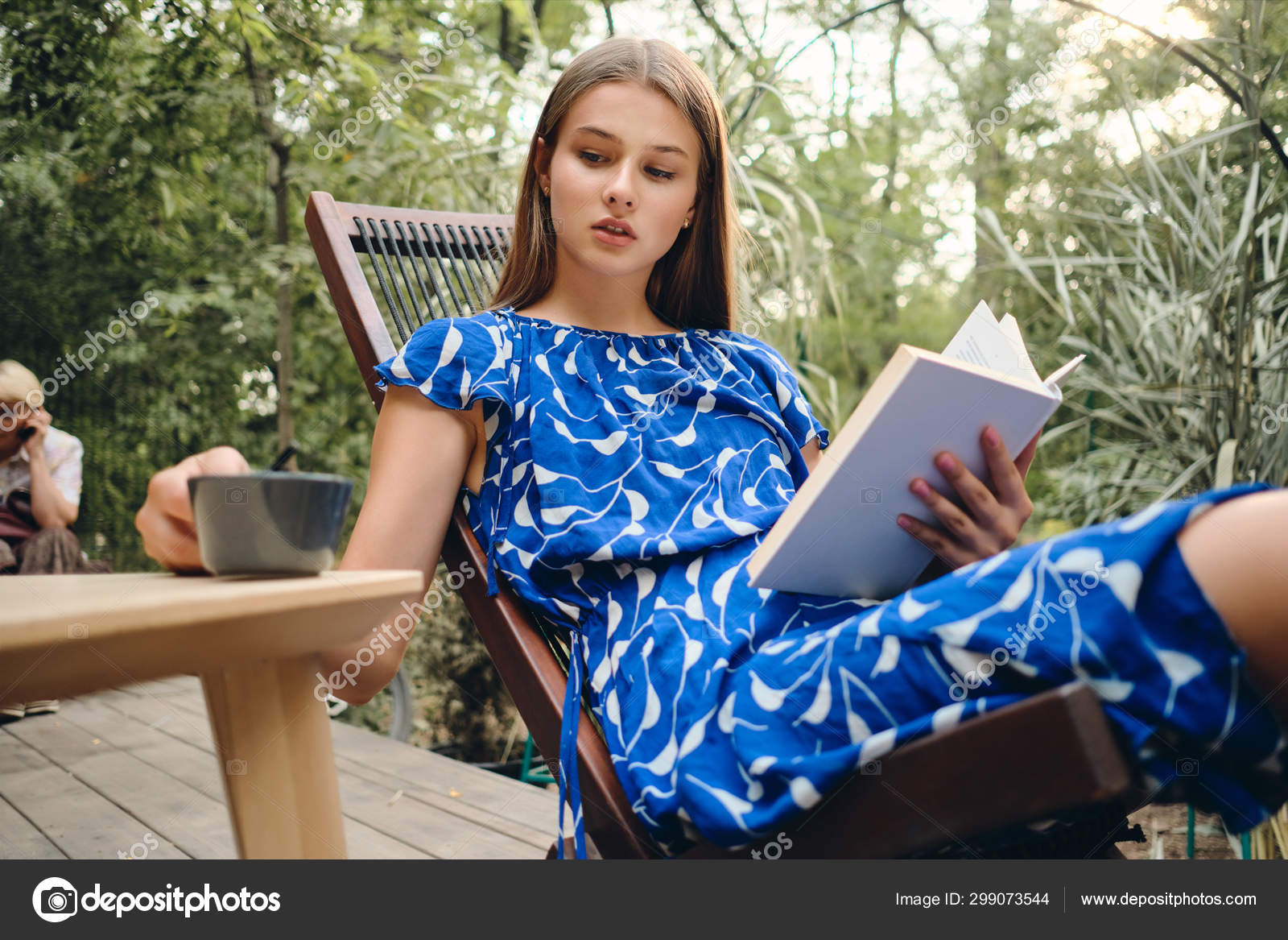 Jeune Femme Aux Cheveux Bruns Réfléchis En Robe Bleue Assise Avec Café