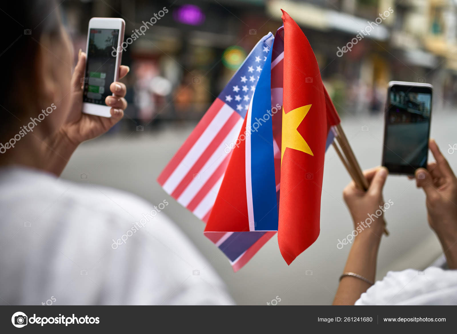 People with flags taking photos of diplomatic escort car passage ...