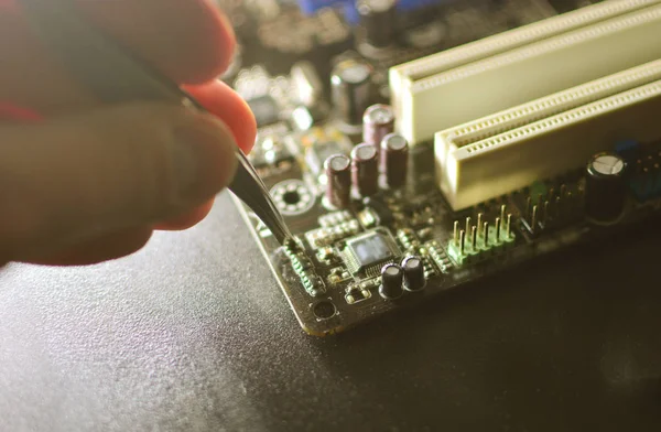 Smd electronic components background. Hand with tweezers holds resistor ...