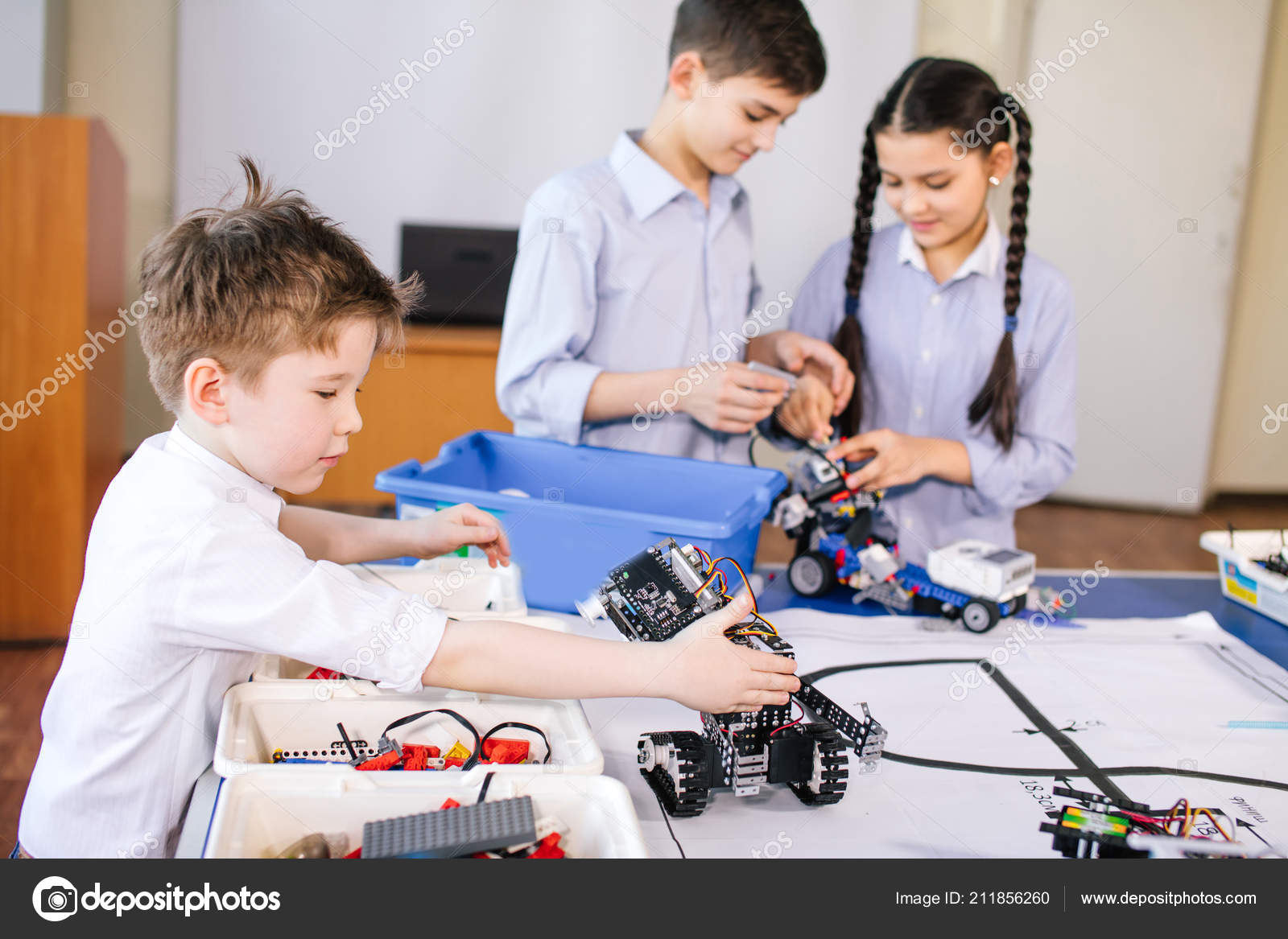Kids playing with electrical robot while visiting robotics exhibition ...