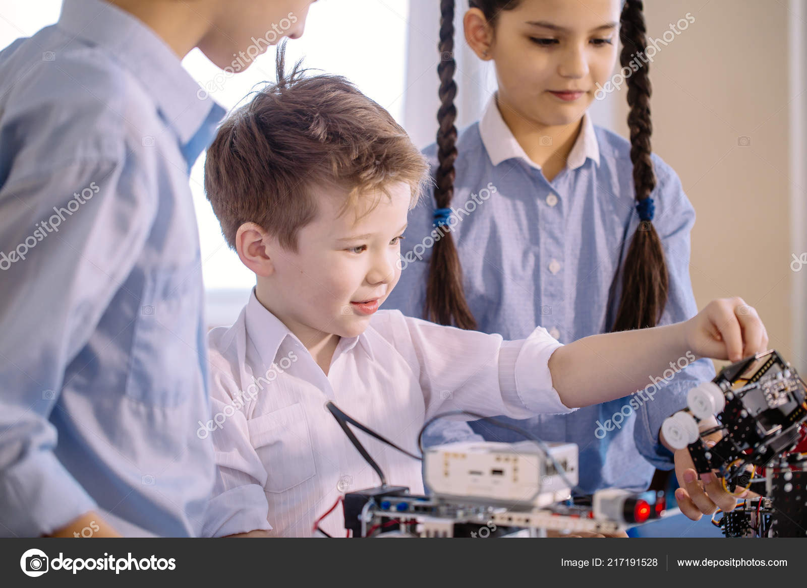 Kids playing with electrical robot while visiting robotics exhibition ...