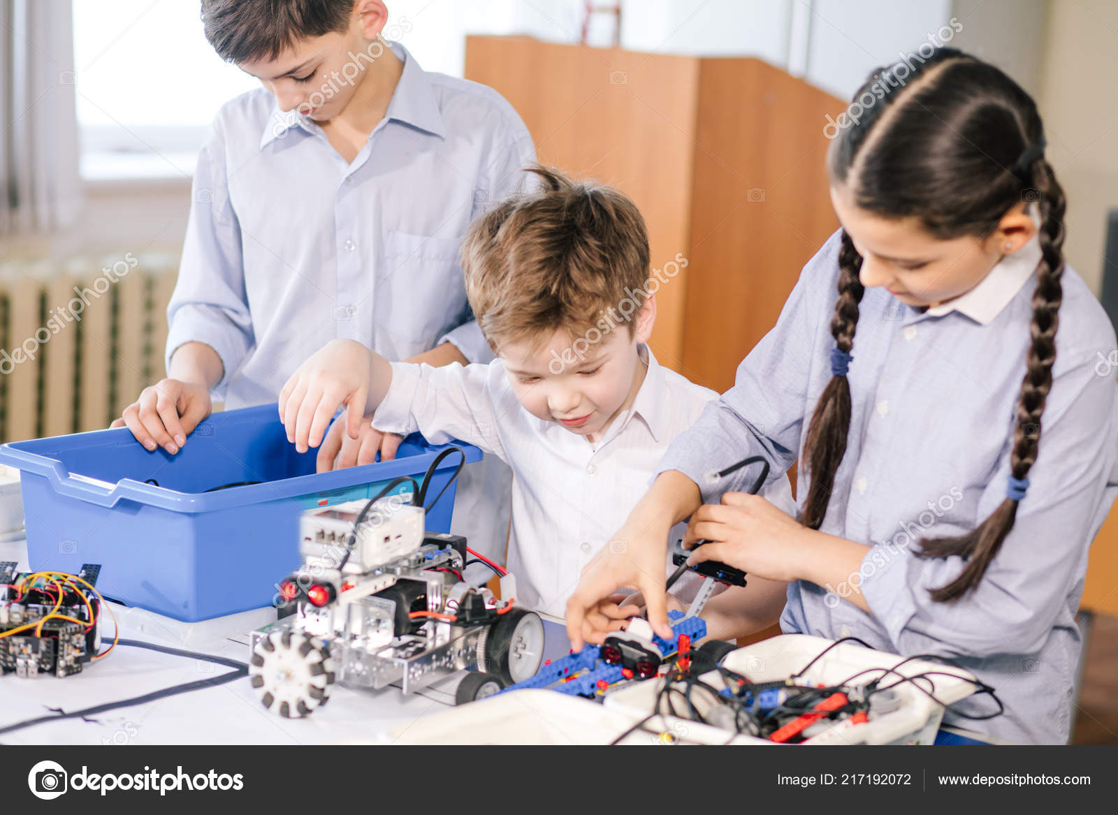Kids playing with electrical robot while visiting robotics exhibition ...