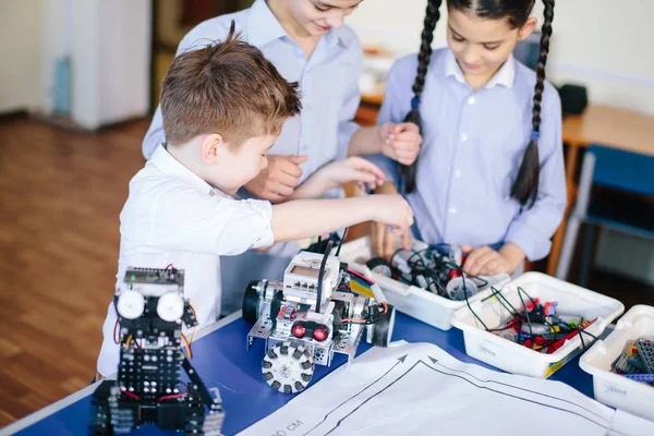 Kids playing with electrical robot while visiting robotics exhibition ...