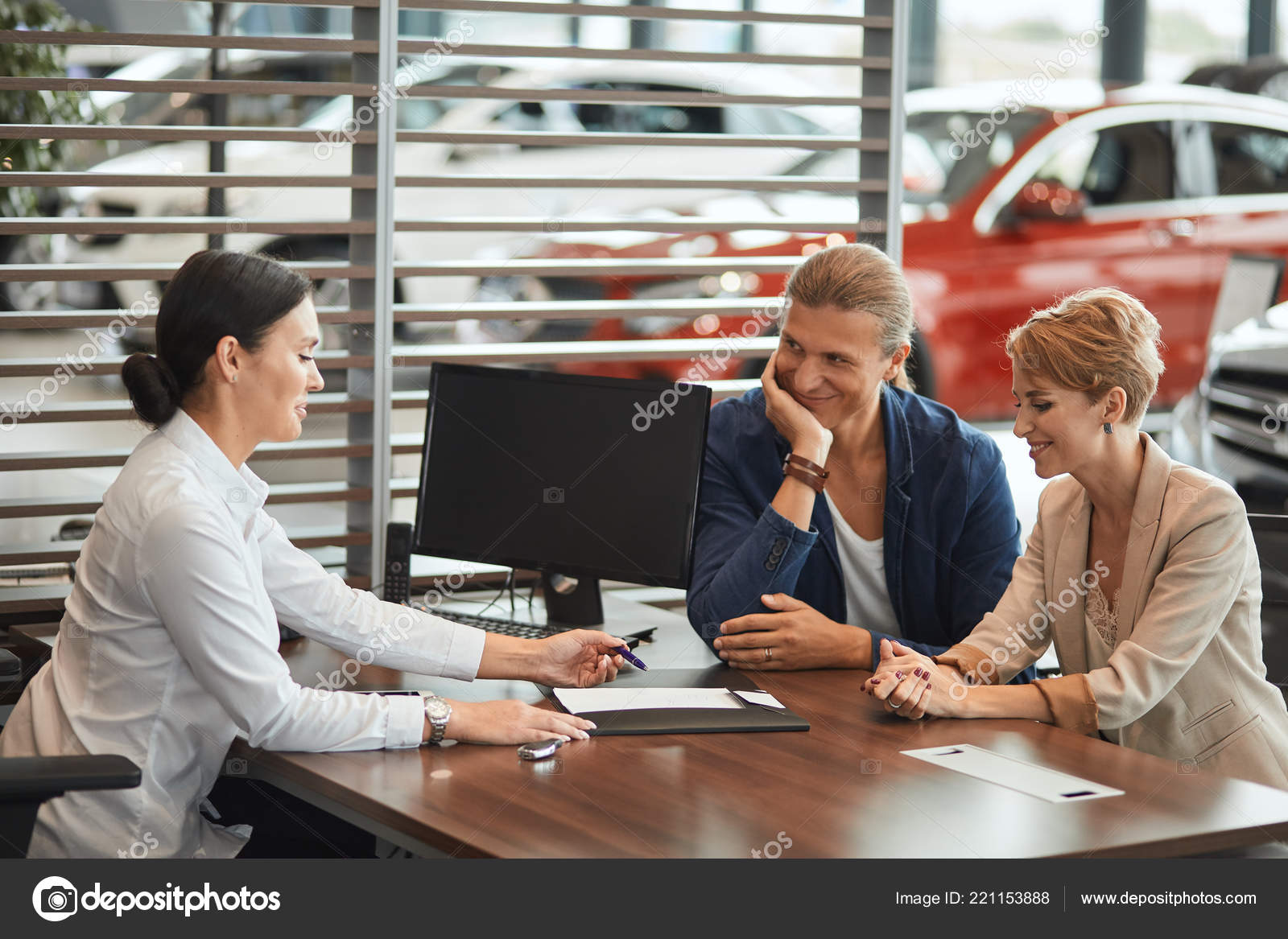 Beautiful young couple signs documents at dealership showroom. — Stock ...