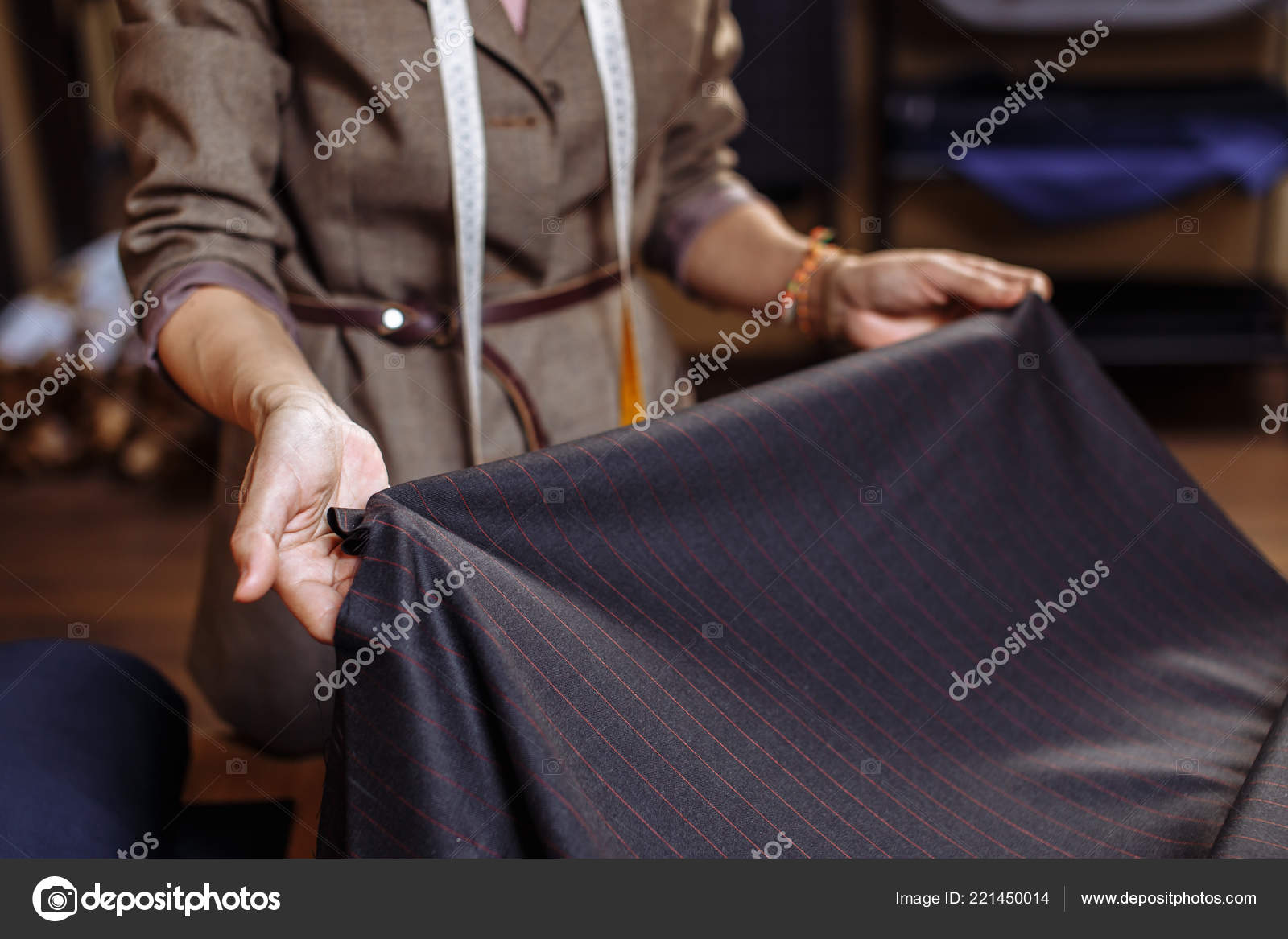 Female tailor choosing fabric for pattern cutting. Mens Wear industry ...