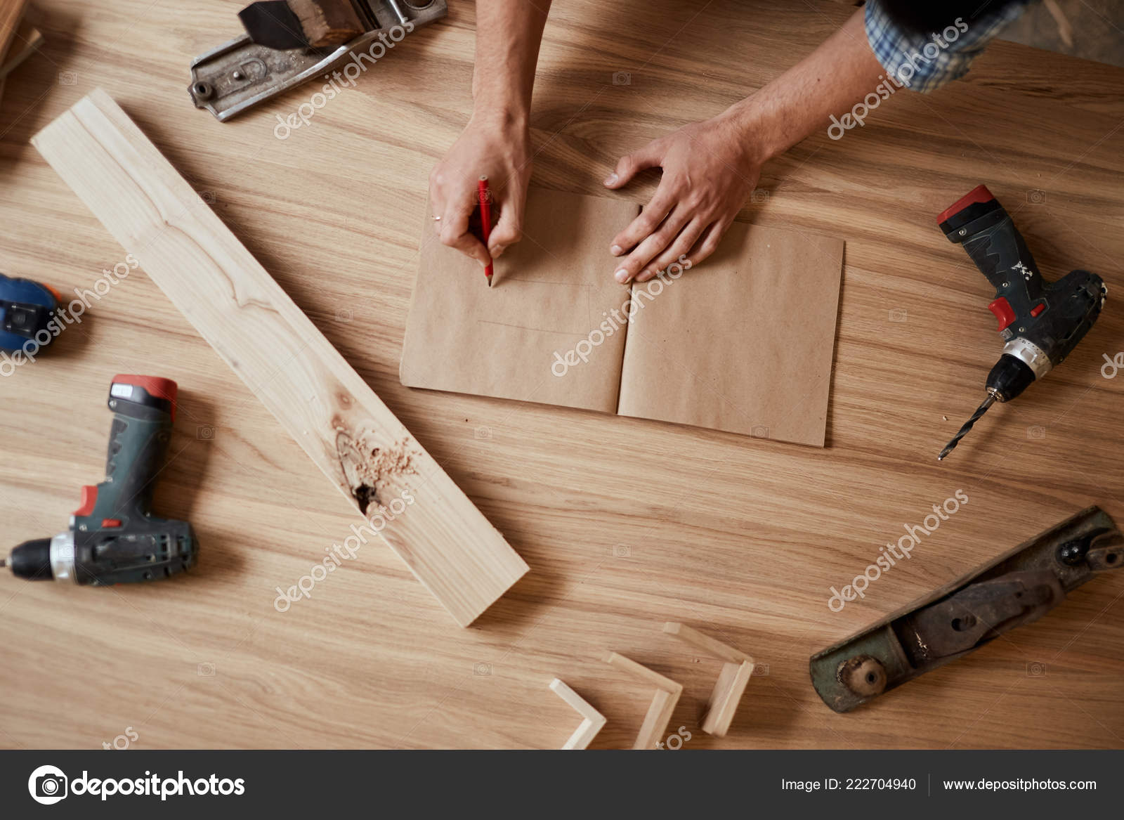 Closeup view of a carpenter using a red pencil to draw a line on a ...