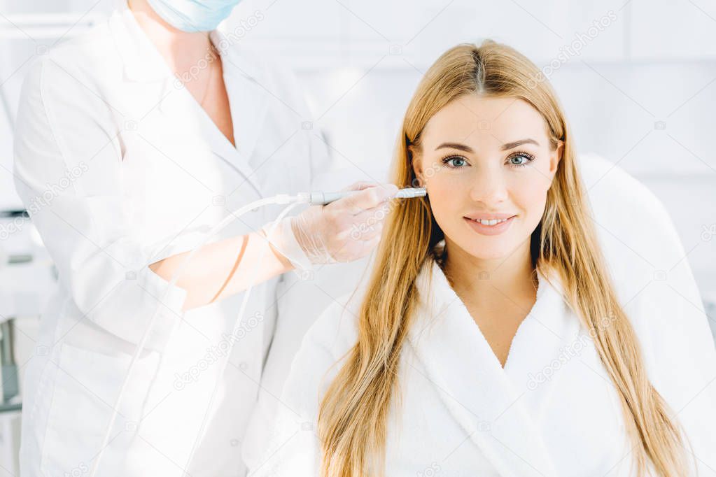 Mujer rubia se somete a un procedimiento de descamación facial gas ... Mujer rubia se somete a un procedimiento de descamación facial gas ...