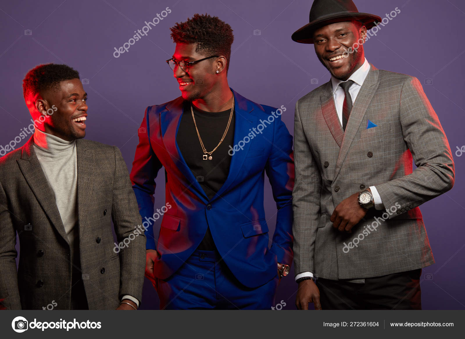 A group of three black men in stylish suits posing isolated in studio ...